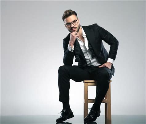 نمای جانبی یک مرد مد معمولی که روی پس‌زمینه خاکستری نشسته و از دوربین دور می‌شود 1082525