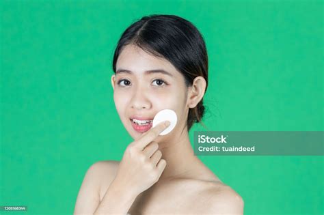 예쁜 아름다움 젊은 아시아 여자 녹색 고립 된 배경 위에 면 패드와 그녀의 얼굴을 청소 건강 한 피부와 화장품 컨셉 건강한 생활
