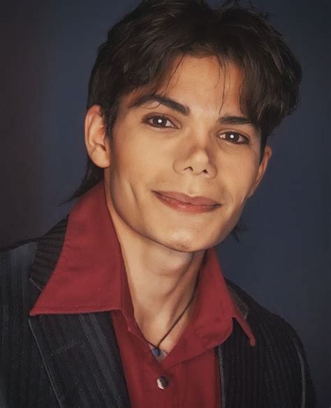 A Man In A Red Shirt And Black Jacket