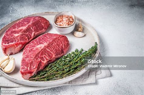 생 굴 탑 블레이드 또는 허브와 접시에 플랫 철 로스트 쇠고기 고기 스테이크 흰색 배경입니다 맨 위 보기 복사 공간 0명에 대한