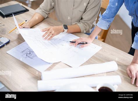Concept Of Engineering Consulting Two Female Engineers Is Checking Blueprint Of Building