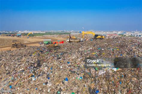 在工業工廠內鳥瞰堆放各類大型垃圾堆塑膠袋和垃圾用拖拉機車造成的環境污染傾倒場的廢物處理 照片檔及更多 垃圾 照片 垃圾 小山 燃燒