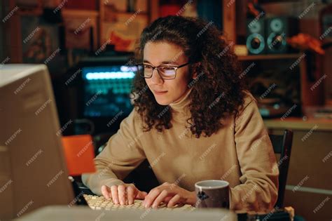 Premium Photo | Young programmer in eyeglasses sitting at table in front of computer developing ...
