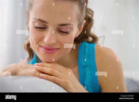 Portrait Of Happy Young Woman Sitting On Sofa In Living Room Stock