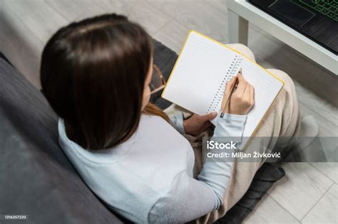 집에서 바닥에 앉아있는 동안 빈 종이 페이지에 쓸 준비가 연필을 들고 알 수없는 여성 여학생의 손에 노트북에 최고 보기 온라인