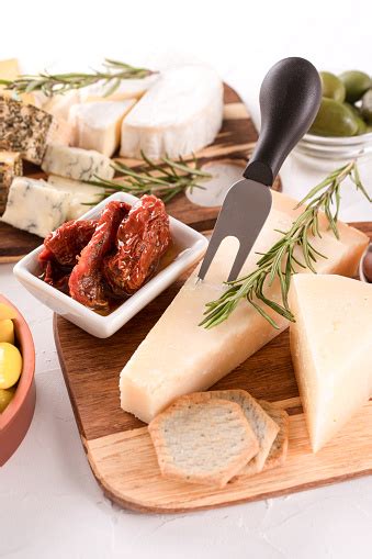 단단하고 부드럽게 익은 치즈 치즈 조각과 전통 이탈리아 전채 요리의 구색이있는 Charcuterie 보드 흰색 테이블에 치즈
