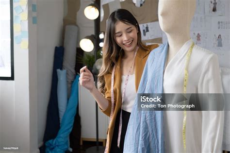 스케치 라인에서 직물을 자르는 행복한 여성 양장점 패션 스튜디오에서 일하는 새로운 옷 컬렉션을 디자인하는 패션 디자이너