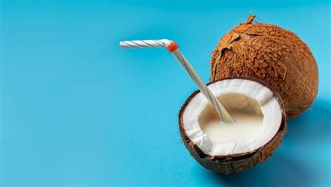 Premium Photo Open Coconut With Straw On Blue Background Tropical