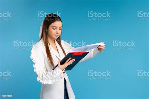 클립 보드와 자신감 젊은 비즈니스 여성 클립보드를 들고 성공적인 사업가의 초상화 흰색 코트를 입고 문서를 손에 들고 있는 여성