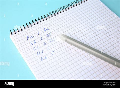Letters And Numbers Written In Notepad With Erasable Pen On Light Blue Background Closeup Stock