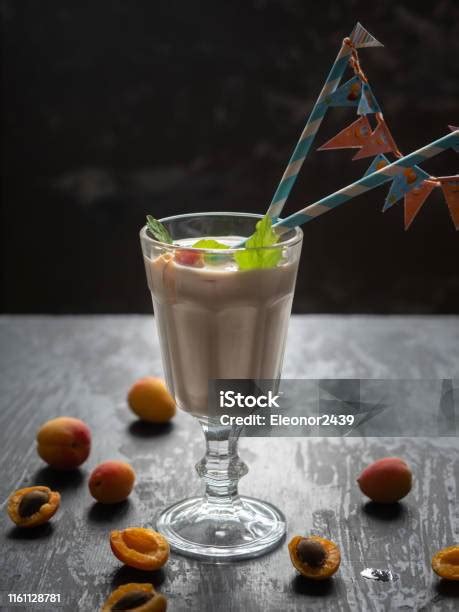 큰 유리 잔에 과일 살구와 바나나두꺼운 밀크 쉐이크 밝은 축제 날을위한 깃발종이 튜브 회색 배경에 살구 몇 가지 측면에서 촬영 0명에 대한 스톡 사진 및 기타 이미지