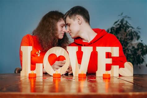 Premium Photo Man And Woman Sitting Next To Each Other In Front Of A