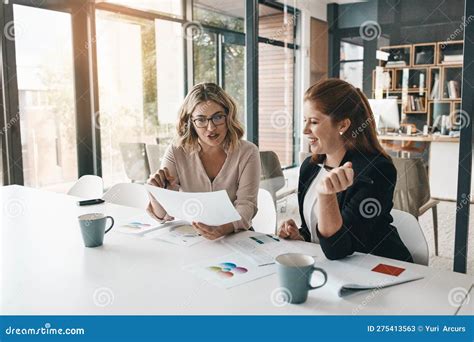 Scanning The Latest Reports Two Businesswomen Going Through Paperwork Together In An Office