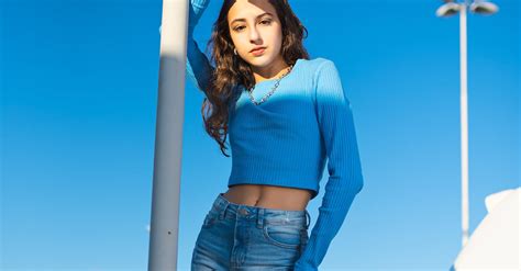 A Woman In Blue Long Sleeve Shirt And Blue Denim Jeans Standing Beside