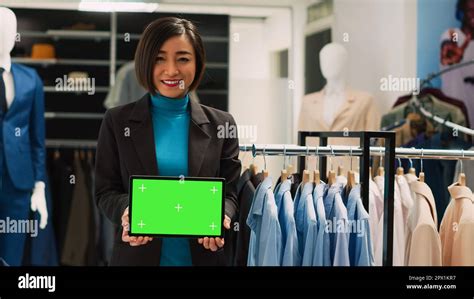Female Asian Woman Using Green Screen On Digital Tablet Holding Blank Chroma Key Display In