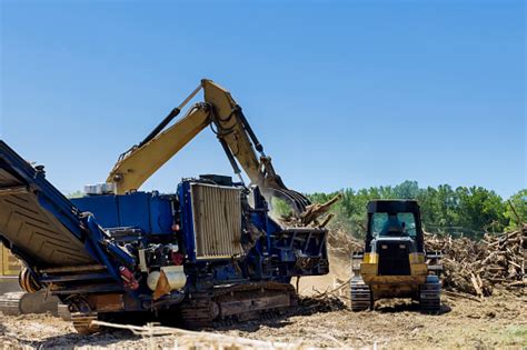 산업용 분쇄기 기계의 도움으로 우리는 주택 개발을 위해 준비중인 토지에 뿌리의 뿌리를 파쇄하고 있습니다 0명에 대한 스톡 사진 및 기타 이미지 Istock