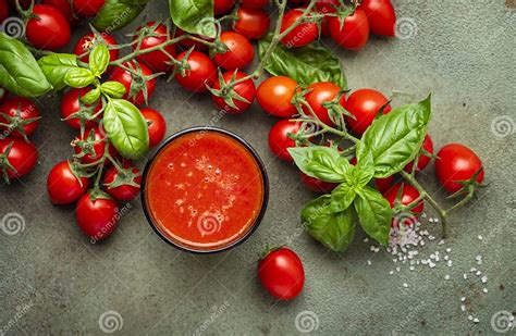 Freshly Squeezed Tomato Juice With Sea Salt In Glass And Red Cherry