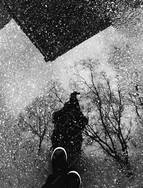 Premium Photo Reflection Of Man On Puddle During Winter