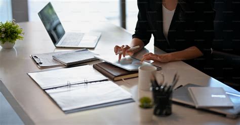 책상에 앉아 디지털 태블릿 컴퓨터에서 작업하는 지능형 사업가의 자른 이미지 사진 Unsplash의 사무실 이미지