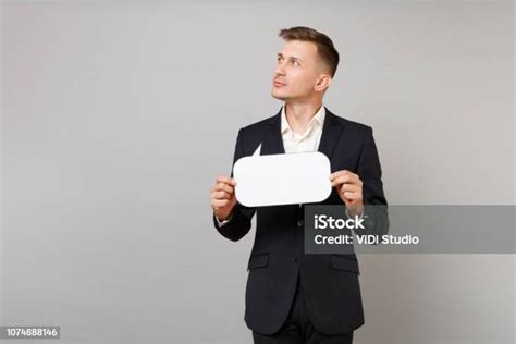 젊은 비즈니스 사람 지주 빈 빈 말 클라우드 연설 거품 프로 모션 콘텐츠 격리에 회색 벽 배경에 대 한 보고 성과 경력 부