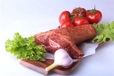 원시 돼지고기 너 클과 야채 마늘 토마토 향신료 양상추 절단 보드에 나뭇잎 선택적 초점입니다 요리에 대 한 준비 건강한 식생활에