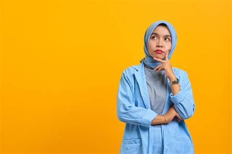 노란 배경 위에 턱에 손가락으로 질문에 대해 생각하는 펜시 브 젊은 아시아 여자 25 29세에 대한 스톡 사진 및 기타 이미지