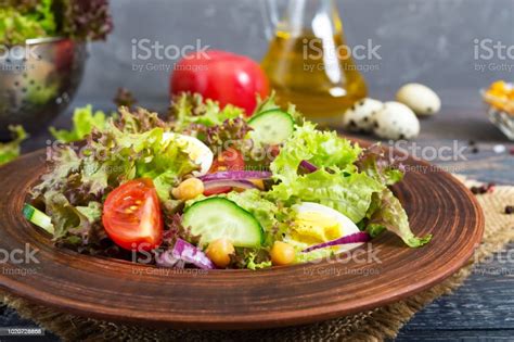 맛 있는 채식 샐러드와 신선한 야채 허브 메 추 라 기 계란 Chickpeas는 찰 흙에 나무 테이블에 그릇 적절 한 영양입니다