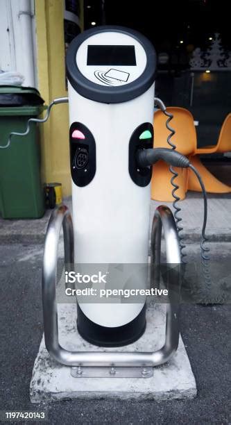 운송 및 녹색 에너지의 미래를 대표하는 하이브리드 자동차의 플러그 소켓에 충전 케이블과 리튬 이온 배터리에 충전 전력이 있는 Ev 충전기 또는 전자 자동차 충전기 0명에