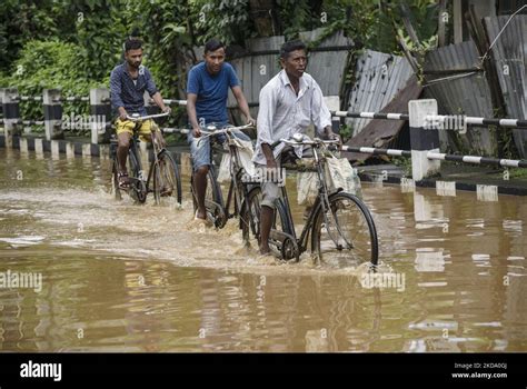 Commuters Make Their Way On A Waterlogged Street After A Heavy Rainfall