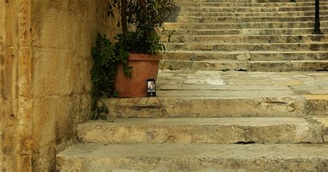 타이머를 실행하는 카메라 앱이 있는 스마트폰은 골동품 거리의 계단에 서 있습니다 전화 화면의 셔터 카운트다운에 3초 숫자가 자동으로 촬영되어 관광지에서 셀카 사진을 찍습니다