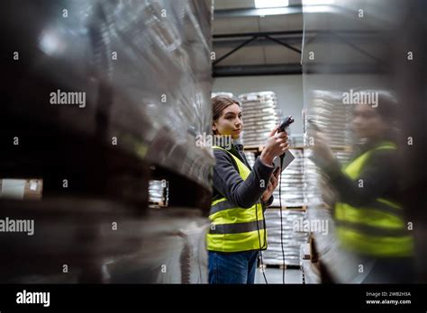 Female Warehouse Worker Holding Scanner Scanning The Barcodes On