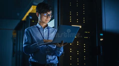 In Dark Data Center Male It Specialist Stands Beside The Row Of