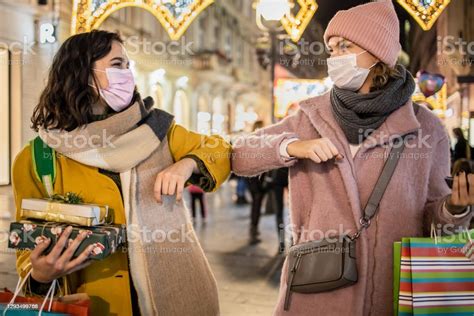 거리에서 서로 인사하는 얼굴 마스크를 가진 두 명의 여성 친구 25 29세에 대한 스톡 사진 및 기타 이미지 25 29세