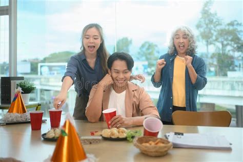 Cheerful Group Of Colleagues Enjoying Snacks And Drinks During A Lively