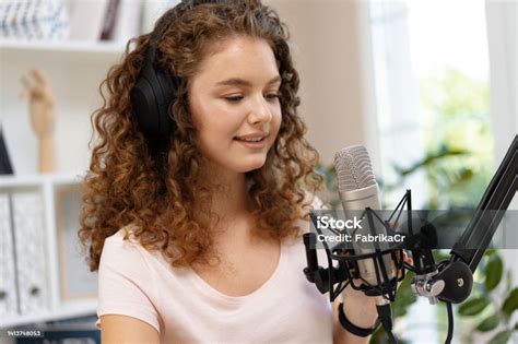 젊은 곱슬 곱슬 한 여성은 집에서 팟 캐스트를 녹음하고 마이크에 담아 이야기합니다 20 24세에 대한 스톡 사진 및 기타 이미지 20 24세 녹음 장비 러시아