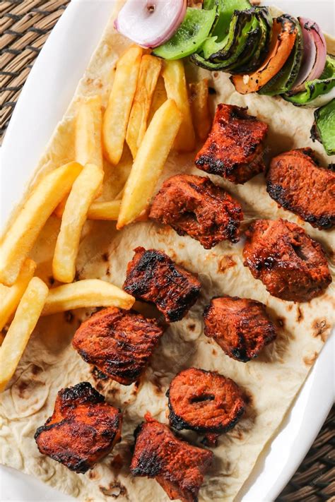 Premium Photo Spicy Bbq Chicken Tikka Boti Kabab With Fries And Salad