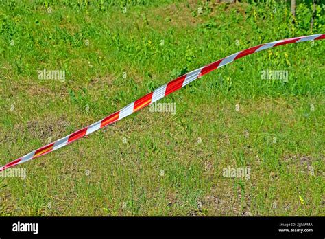Red Security Warning Ribbon On Green Grass Windy Environment Diversity