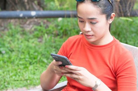 Premium Photo Woman Using Mobile Phone While Sitting Outdoors