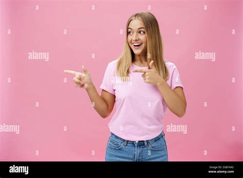 Glücklich fröhlich junge mollige Mädchen mit schönen Haaren zeigt und Blick links mit erfreut