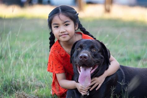 Une Jeune Fille En Tenue Rouge Joue Avec Son Gros Chien Noir Dans La
