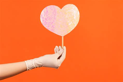하트 핑크 러브 스틱을 들고 흰색 수술 장갑에 인간의 손의 프로필 측면 보기 클로즈업 건강관리와 의술에 대한 스톡 사진 및 기타