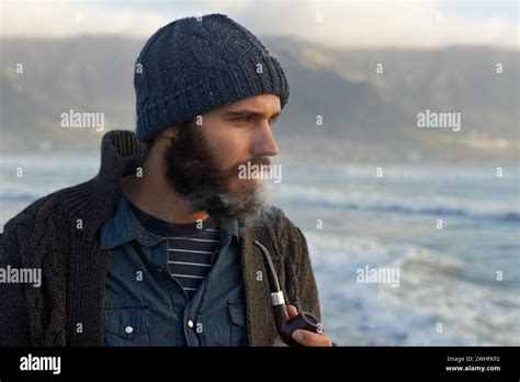 Beard Man And Smoking A Pipe By Ocean Thinking And Sailor Habit On