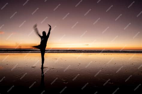 Silueta De Un Niña Bailando En La Playa En Ocaso Foto Premium