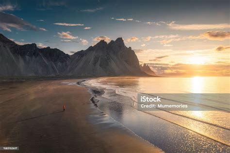 해가 뜰 때 베스트라호른 산과 아이슬란드에서 여름에 스토크스네스 반도의 검은 모래 해변에 서 있는 남자 30 34세에 대한 스톡 사진 및 기타 이미지 Istock