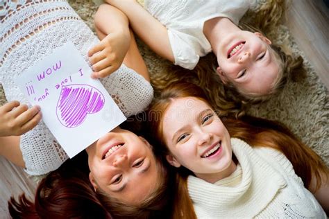 Enfantez Le Mensonge Sur Le Plancher Avec Ses Deux Filles Photo Stock