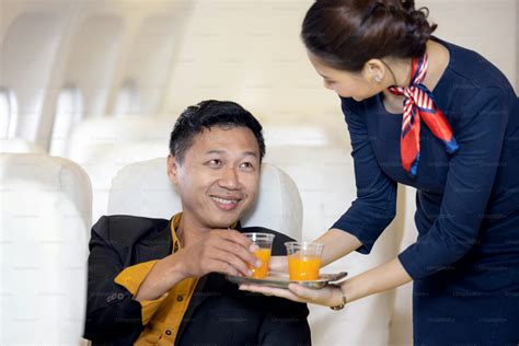 Passenger Have Orange Juice Served By An Air Hostess In Airplane
