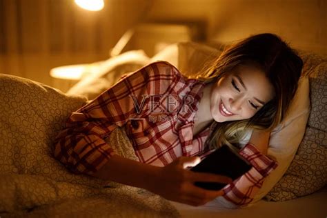 年轻漂亮的女人晚上在床上玩手机照片摄影图片 花瓣网