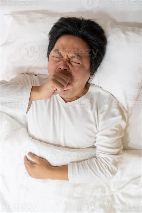 Top Angle View Of Asian Young Man In White Pajamas Has The Chronic