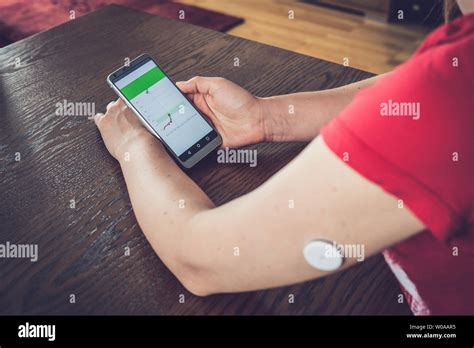 Woman Checking Glucose Level With A Remote Sensor And Mobile Phone New Technology Sensor