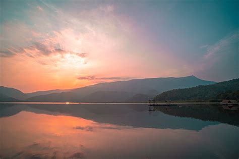 일출에 완벽한 반사와 산 호수의 파노라마 경치 배경에 언덕이 있고 물에 반사 된 분홍색 파스텔 하늘이있는 아름다운 산맥 풍경 자연 호수 풍경 0명에 대한 스톡 사진 및 기타